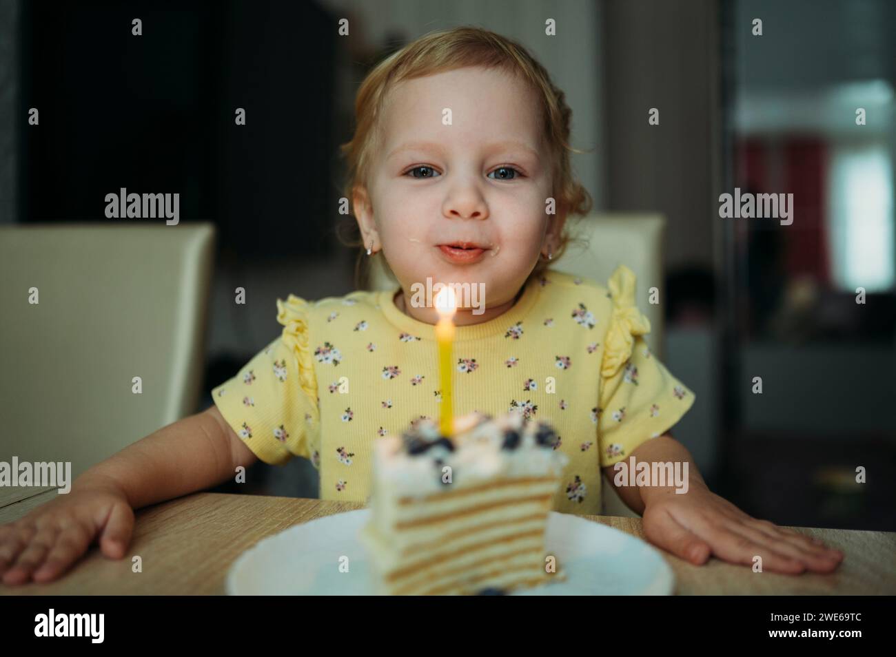 Smiling girl blowing candle on birthday cake at home Stock Photo - Alamy