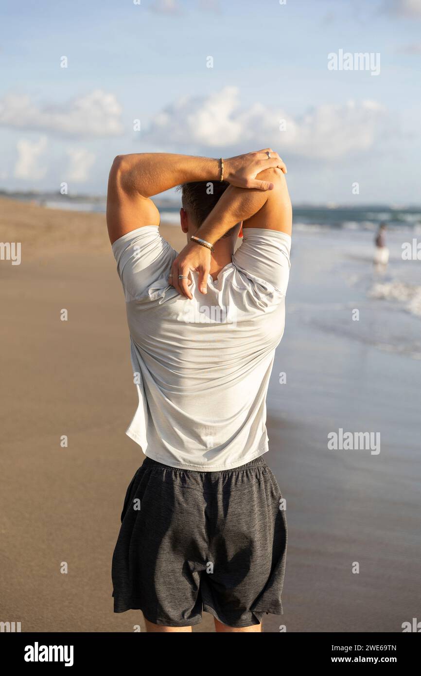 Man doing stretching exercise at beach Stock Photo - Alamy