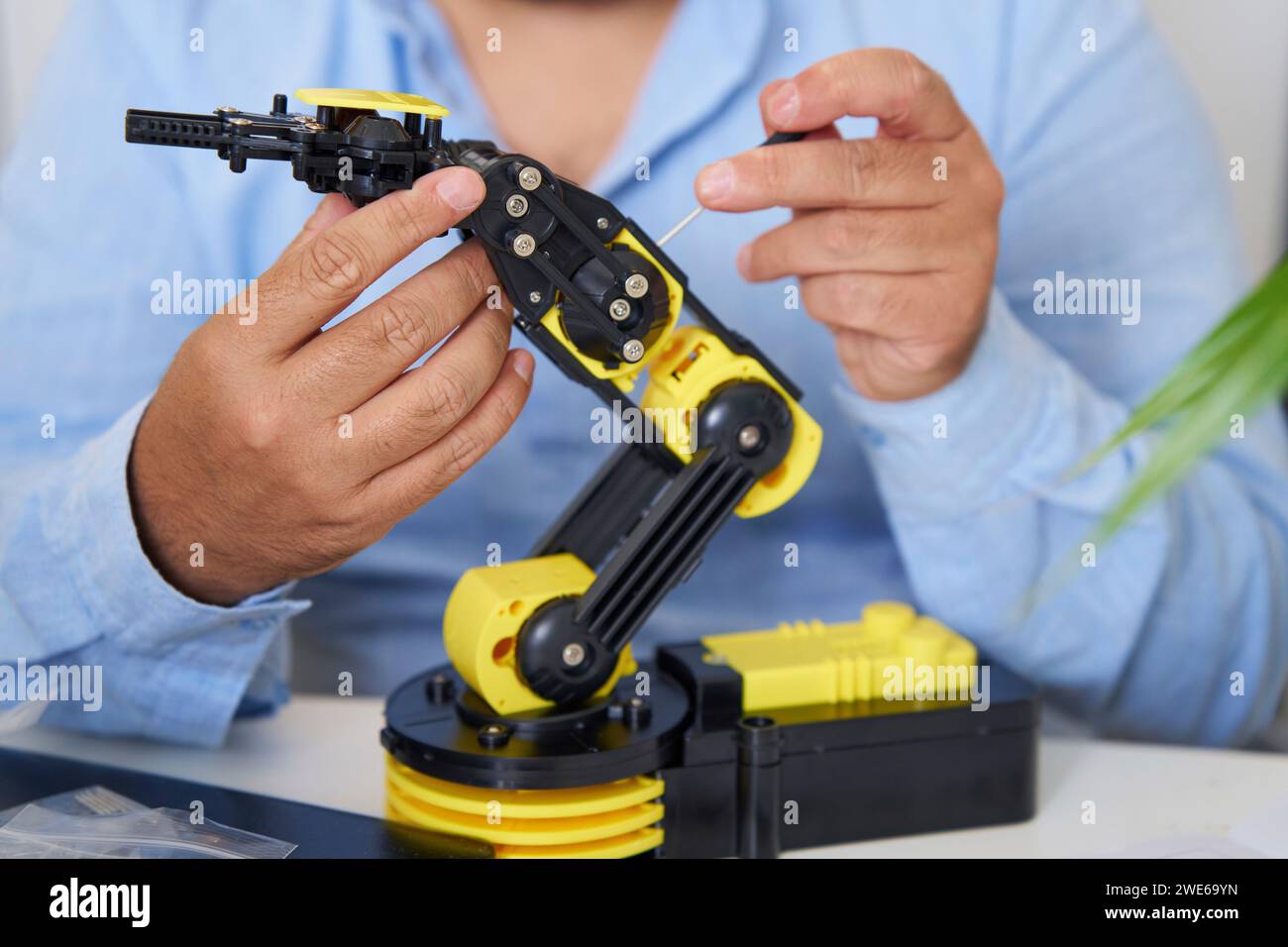 Engineer working on robotic arm in office Stock Photo - Alamy