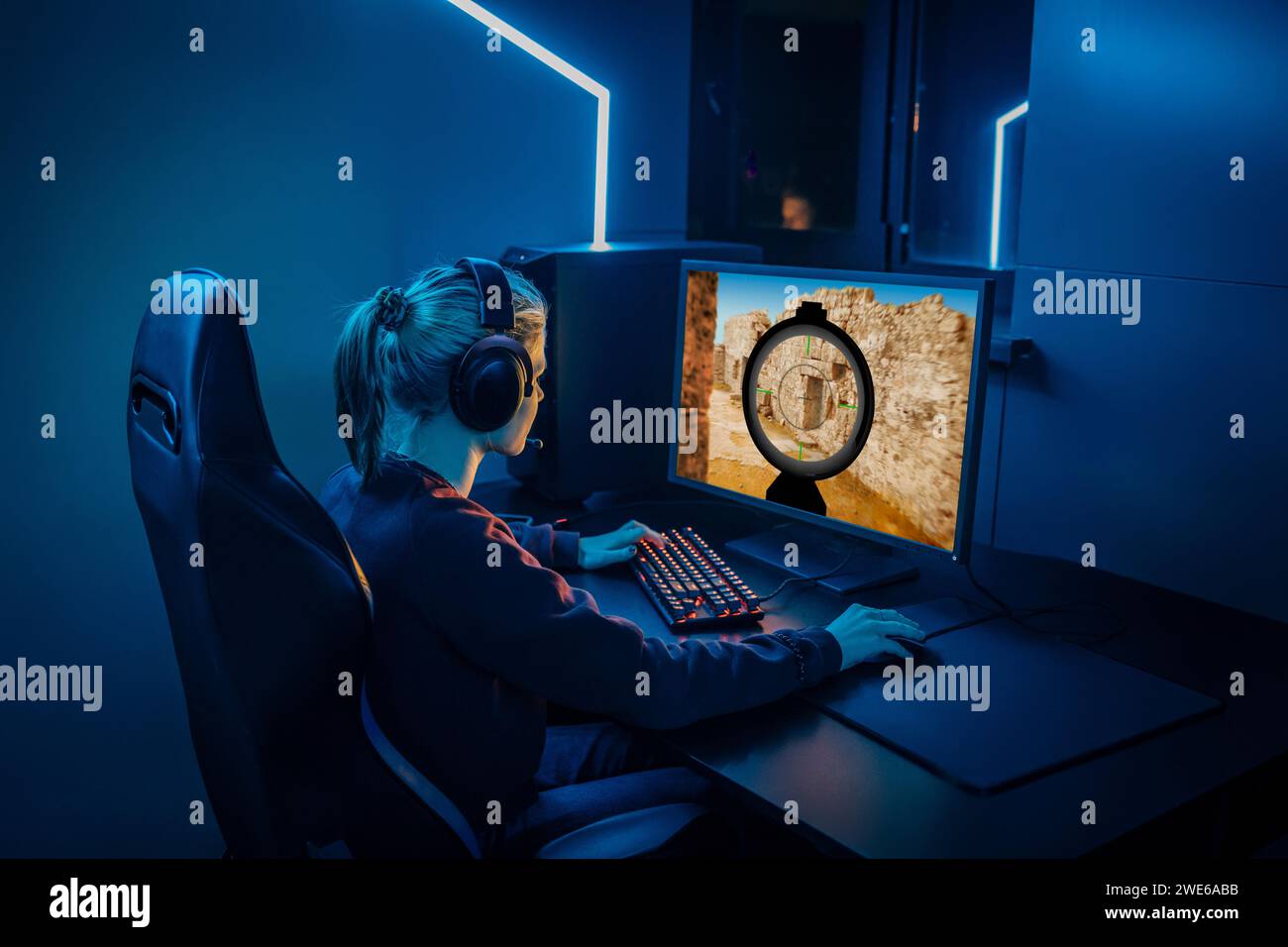 Professional gamer wearing headphones and playing game on computer ...