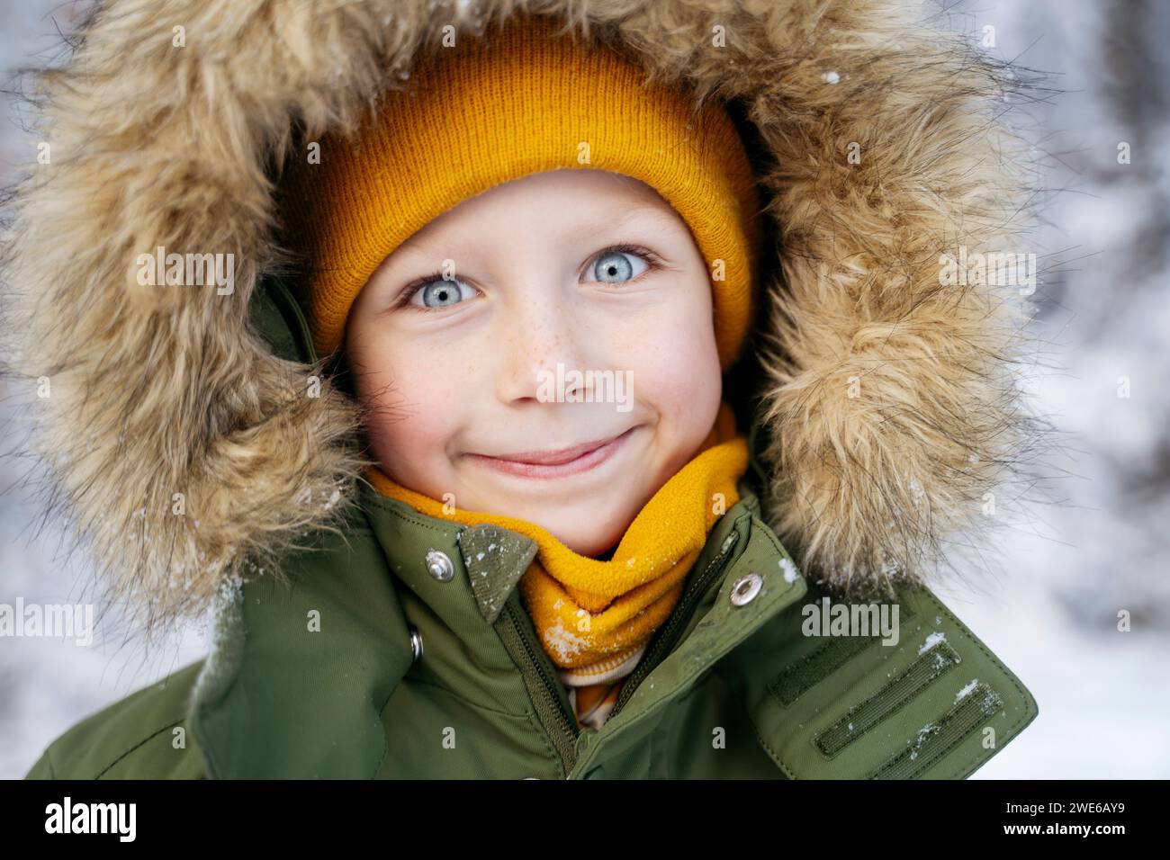 Smiling cute boy wearing parka jacket in snow Stock Photo - Alamy