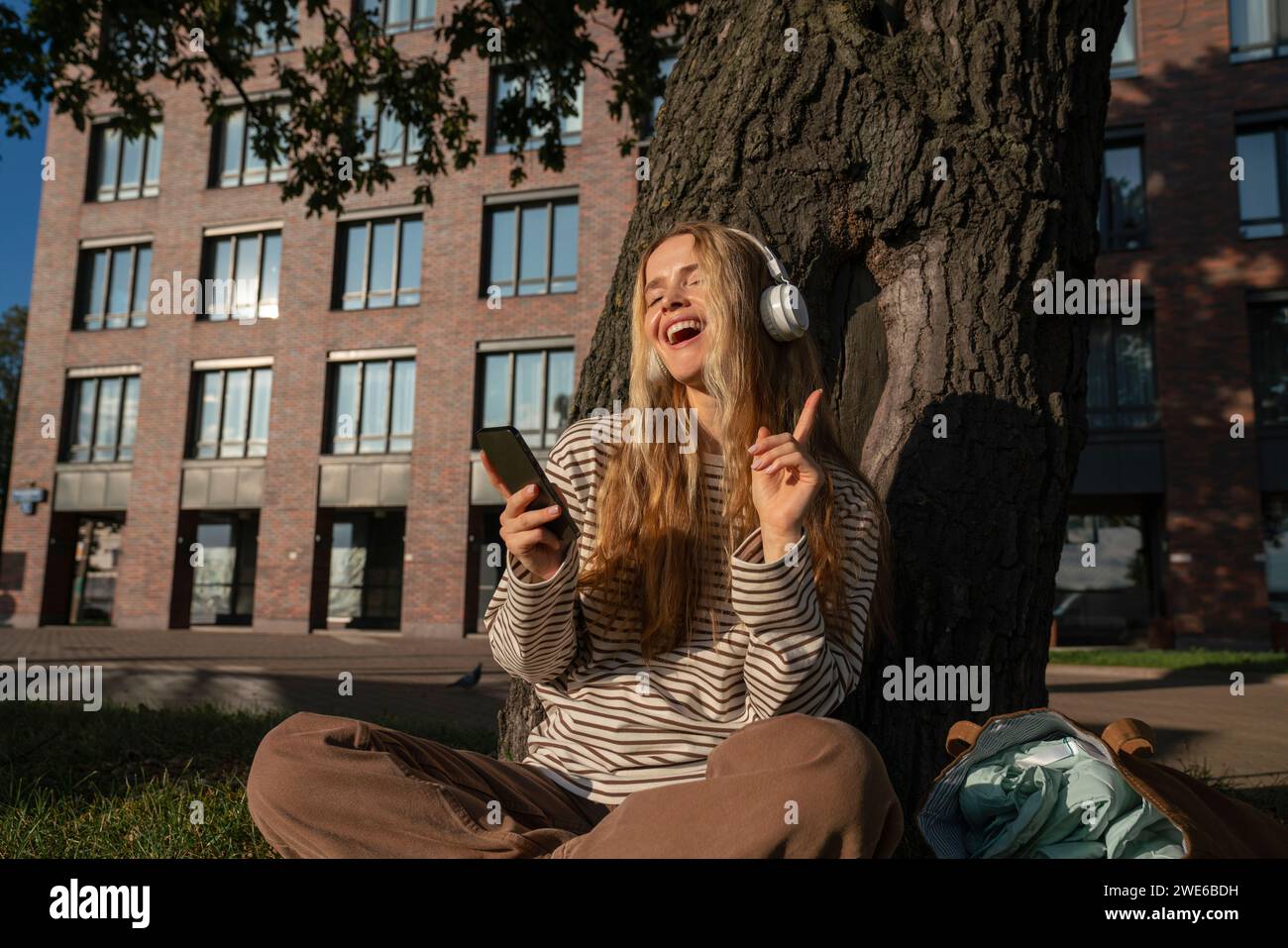 Happy woman enjoys listening to music through wireless headphones Stock ...