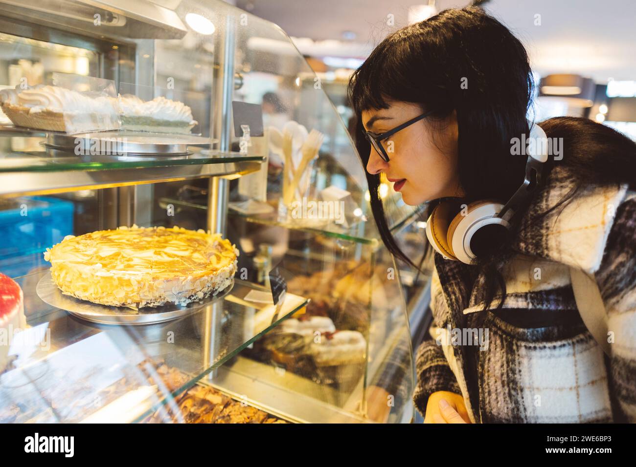 Woman looking at cake on retail display in cafe Stock Photo - Alamy