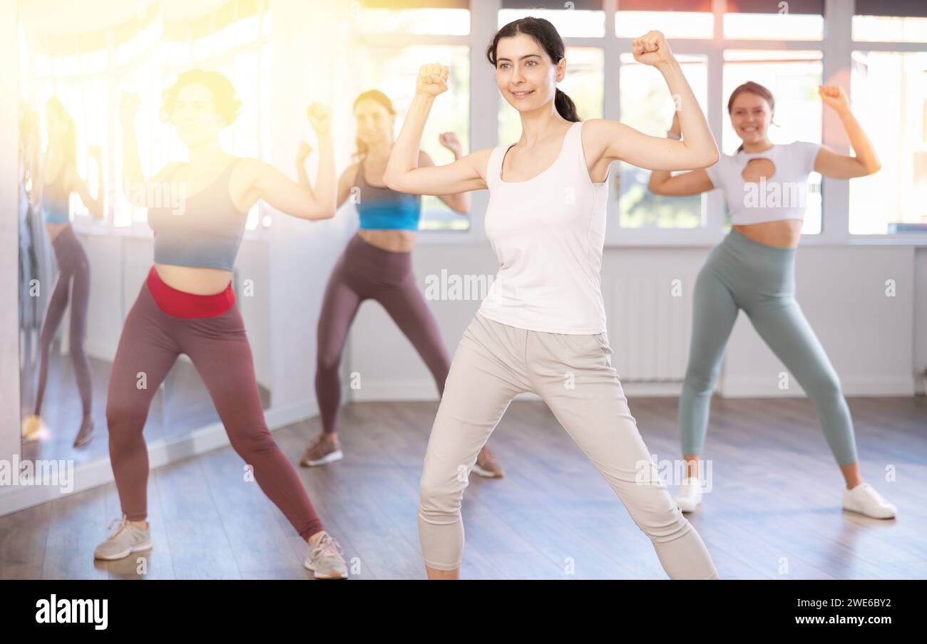 Young female teacher conducts modern hip hop dance lessons for group of ...