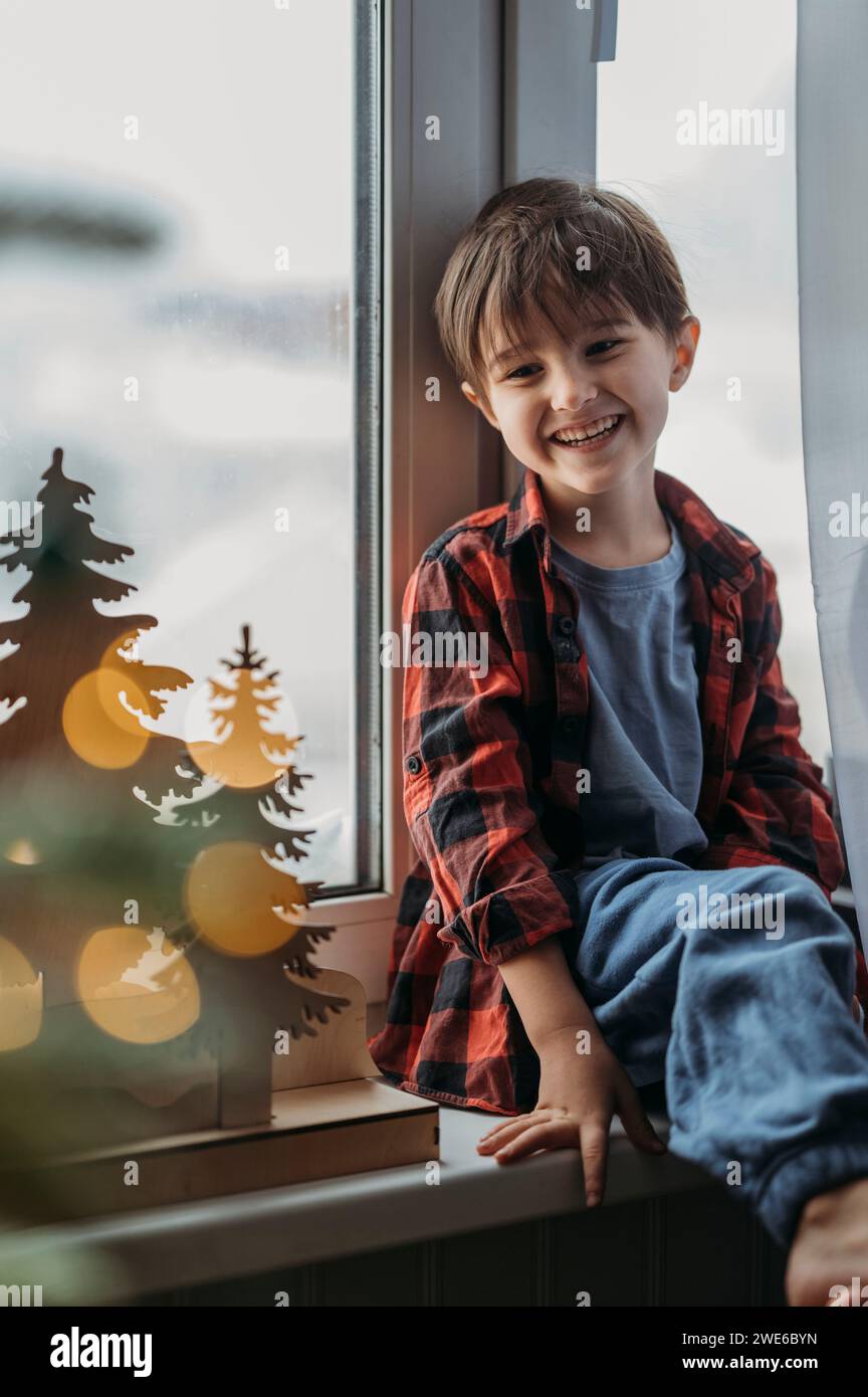 Boy sitting on window sill hi-res stock photography and images - Alamy