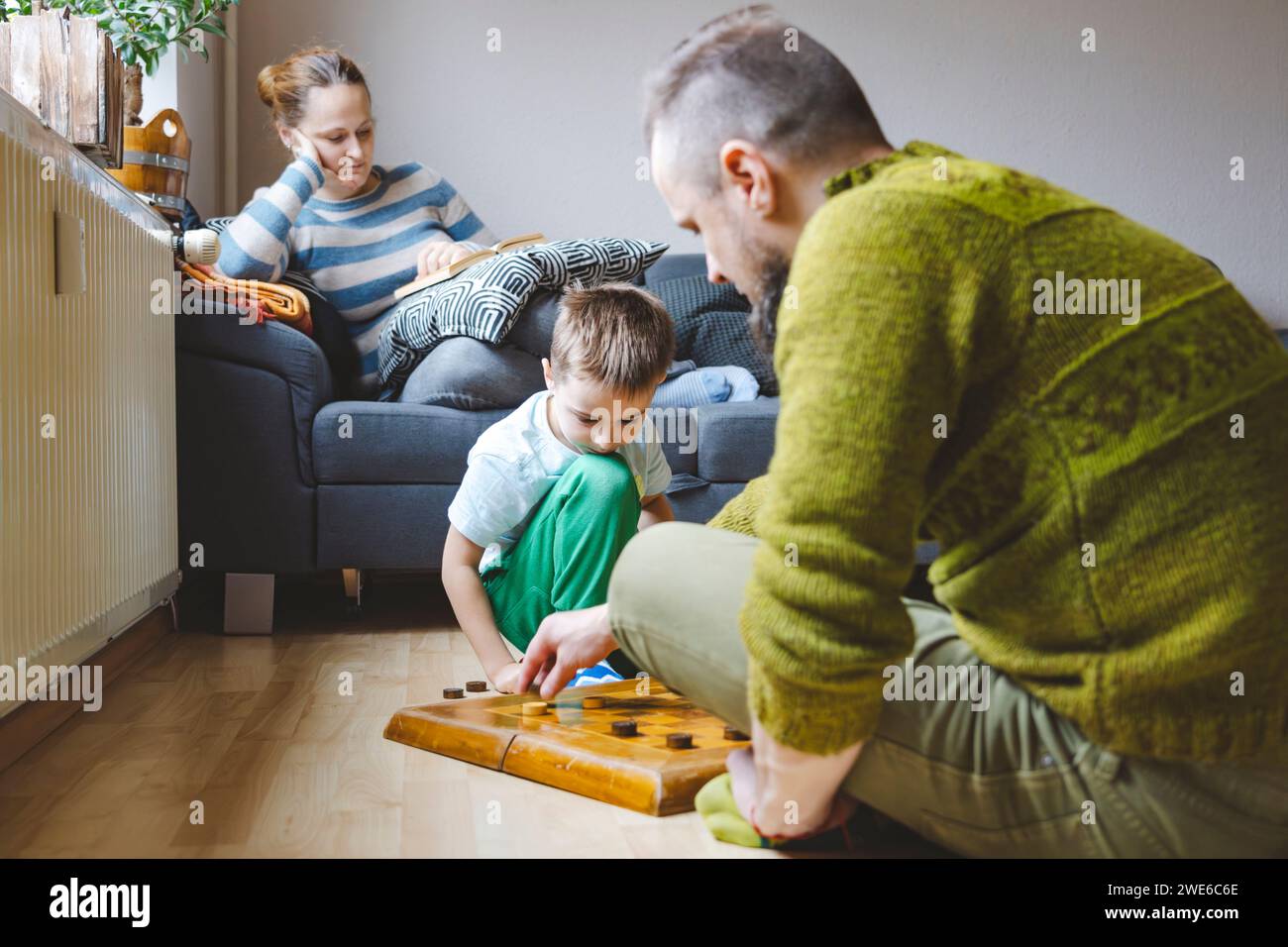 Father playing checkers with son on floor at home Stock Photo - Alamy