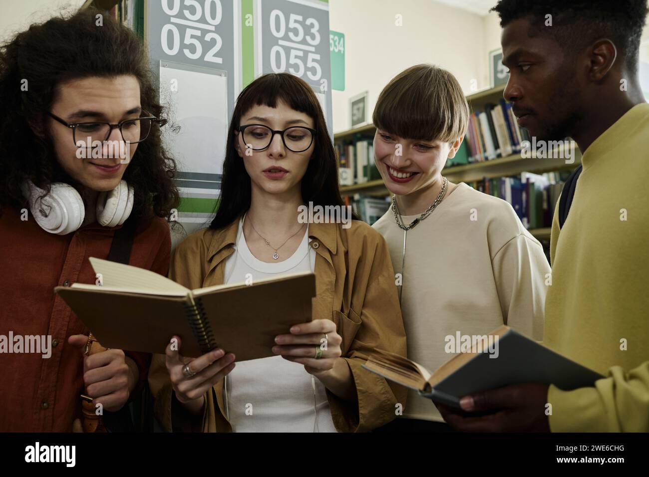 Group of college students studying together in library Stock Photo - Alamy