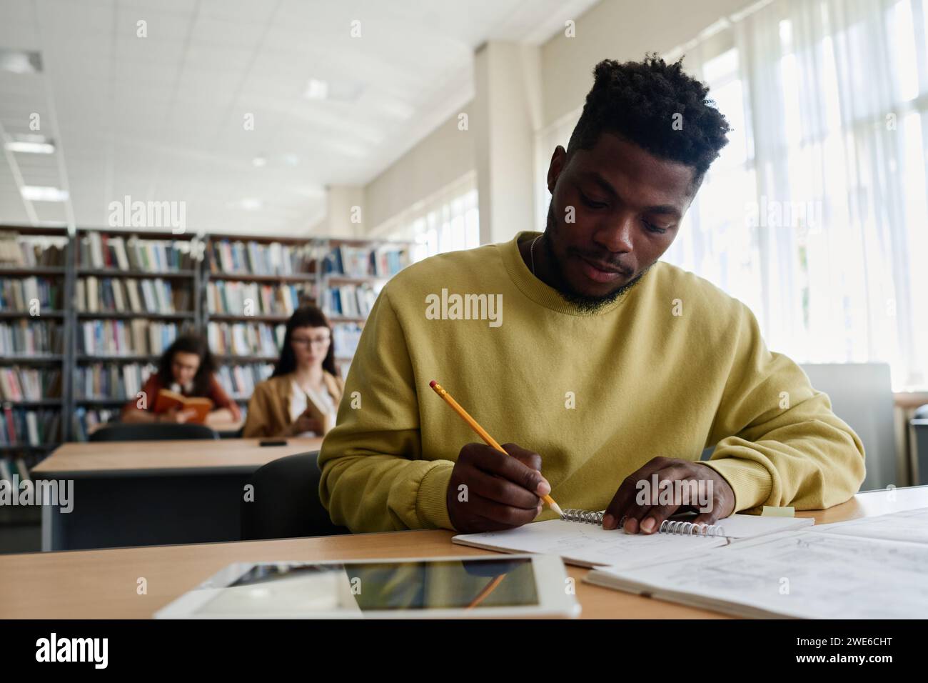 Black student sitting at desk writing hi-res stock photography and ...