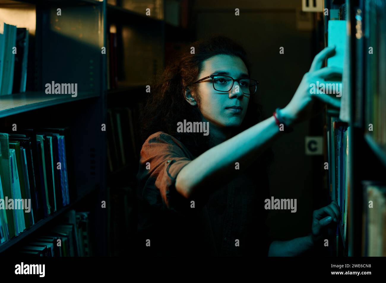 Person choosing book from library hi-res stock photography and images ...