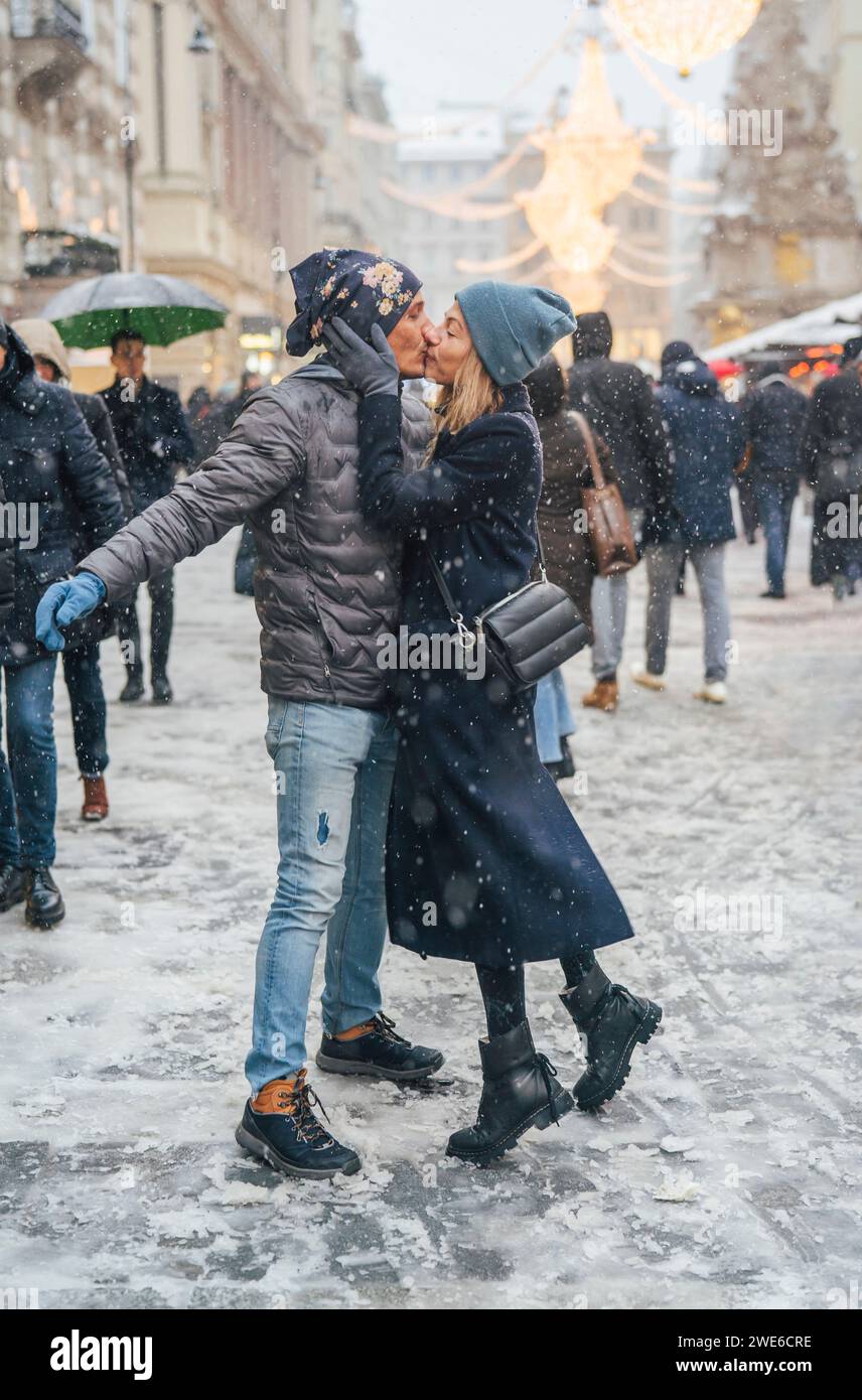 Couple kissing in snow at Christmas market Stock Photo - Alamy