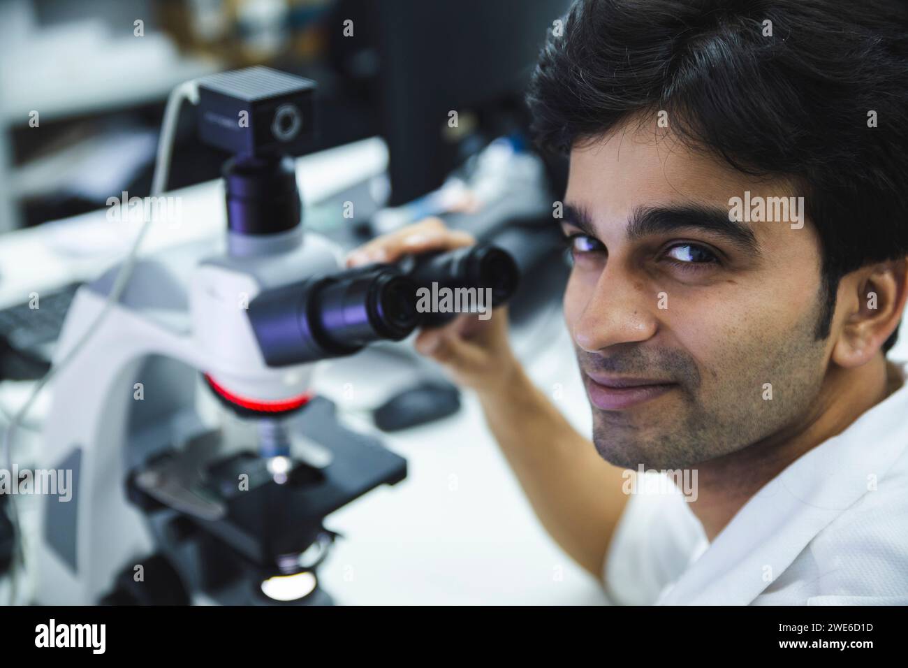 Smiling scientist near microscope at laboratory Stock Photo - Alamy