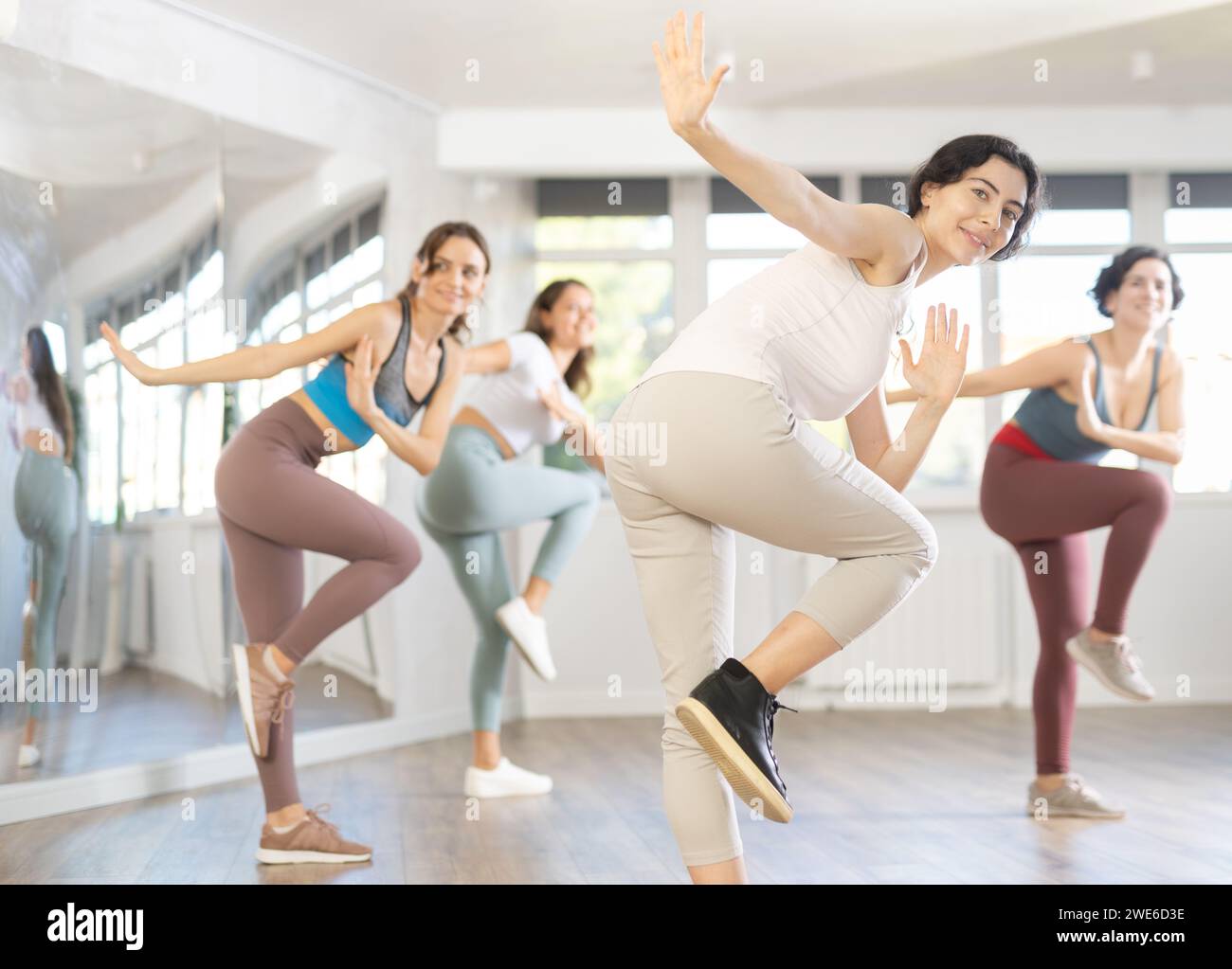 Young female teacher conducts modern dance lessons for group of girls ...