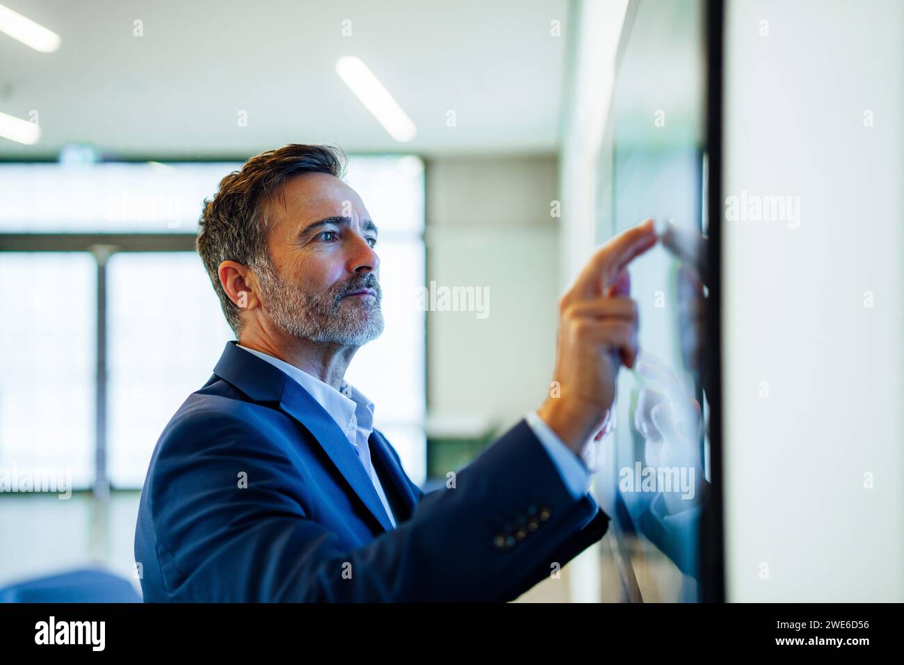 Businessman examining data on computer screen in office Stock Photo - Alamy