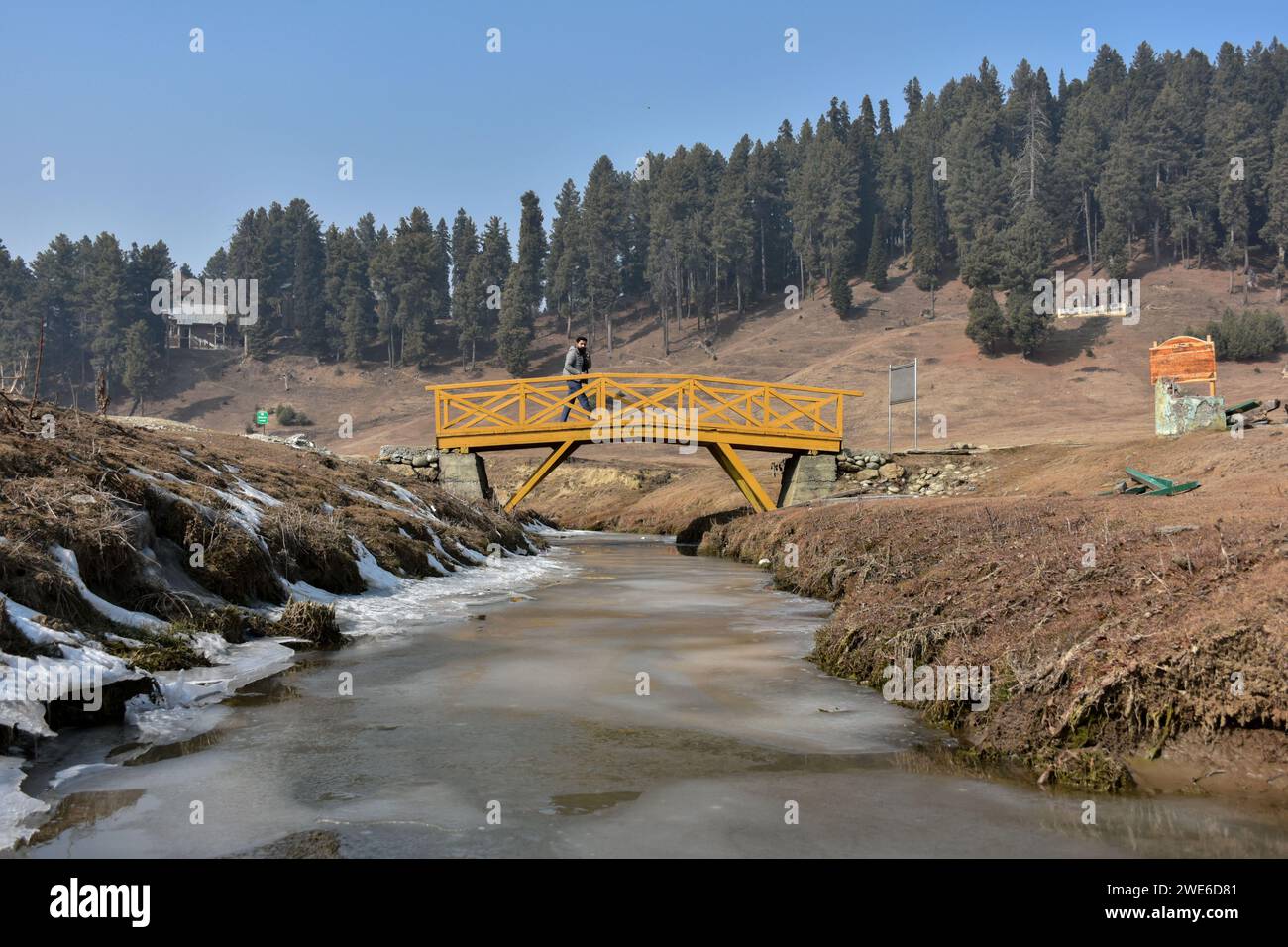 Gulmarg, India. 23rd Jan, 2024. A visitor walks along the wooden foot ...