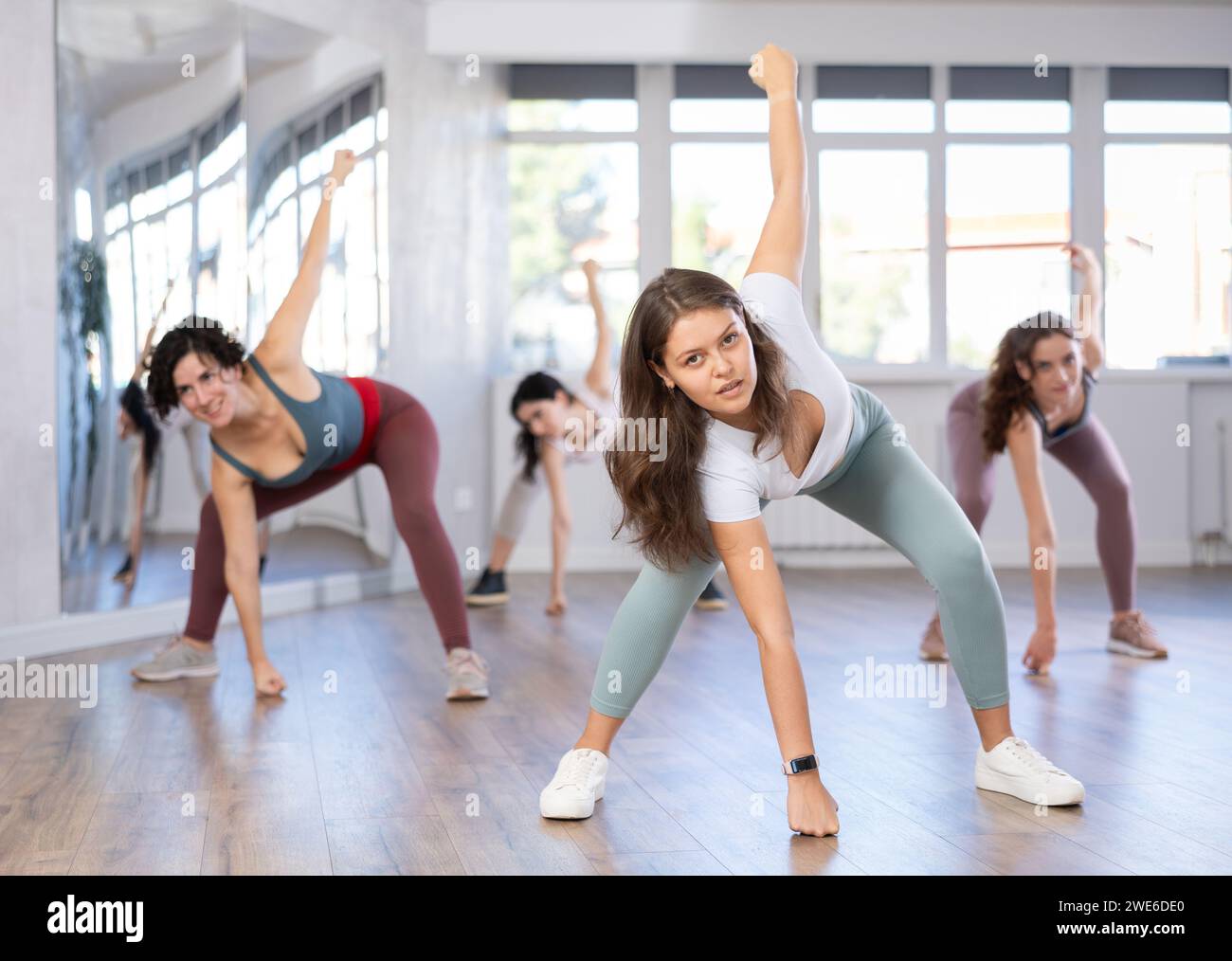 Young female teacher conducts modern hip hop dance lessons for group of ...