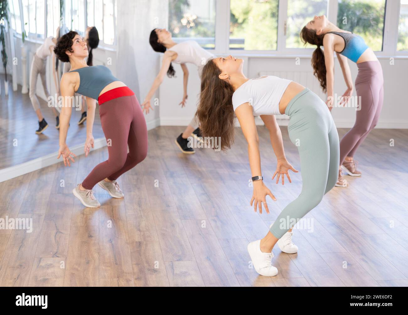 Young female teacher conducts modern hip hop dance lessons for group of ...