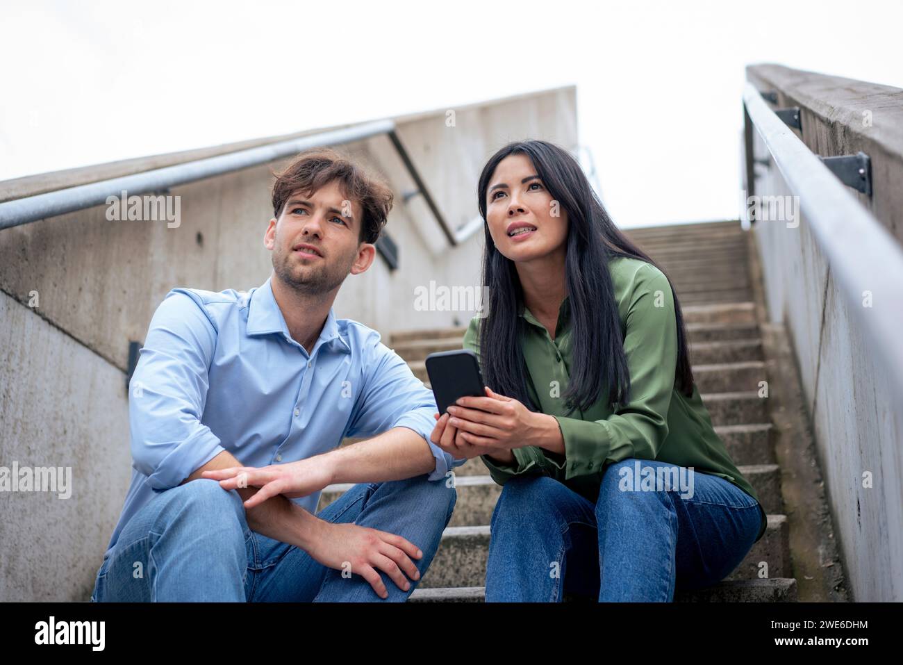 Contemplative multiracial friends sitting on steps Stock Photo - Alamy