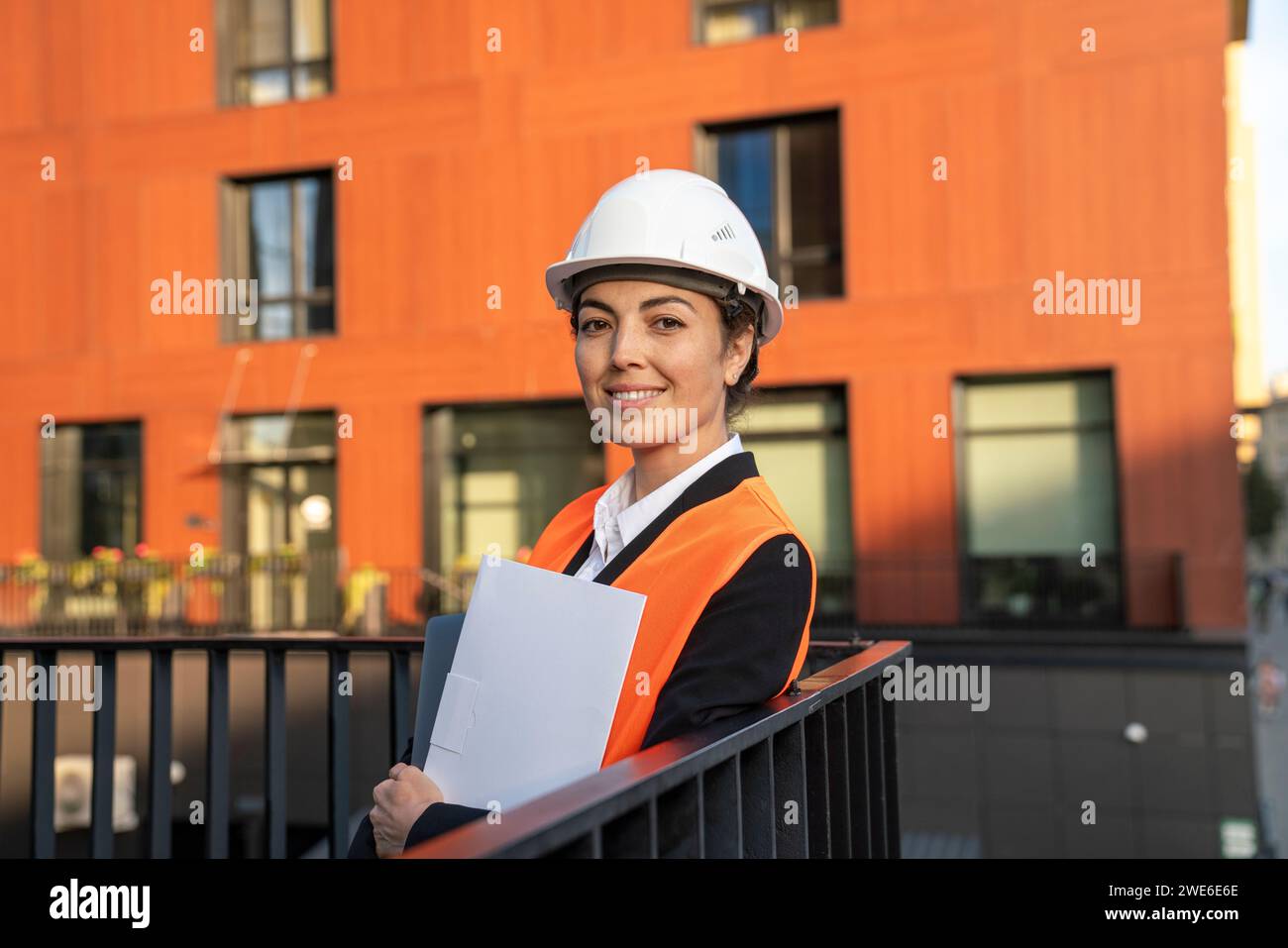 Smiling engineer with standing file folder in balcony Stock Photo - Alamy