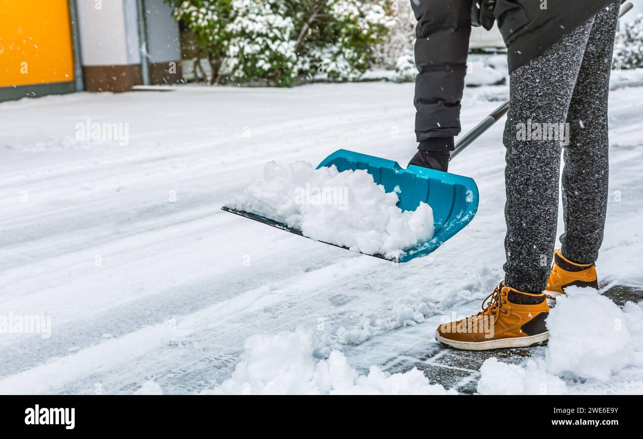 Cleaning snow from street in winter with shovel after snowstorm ...