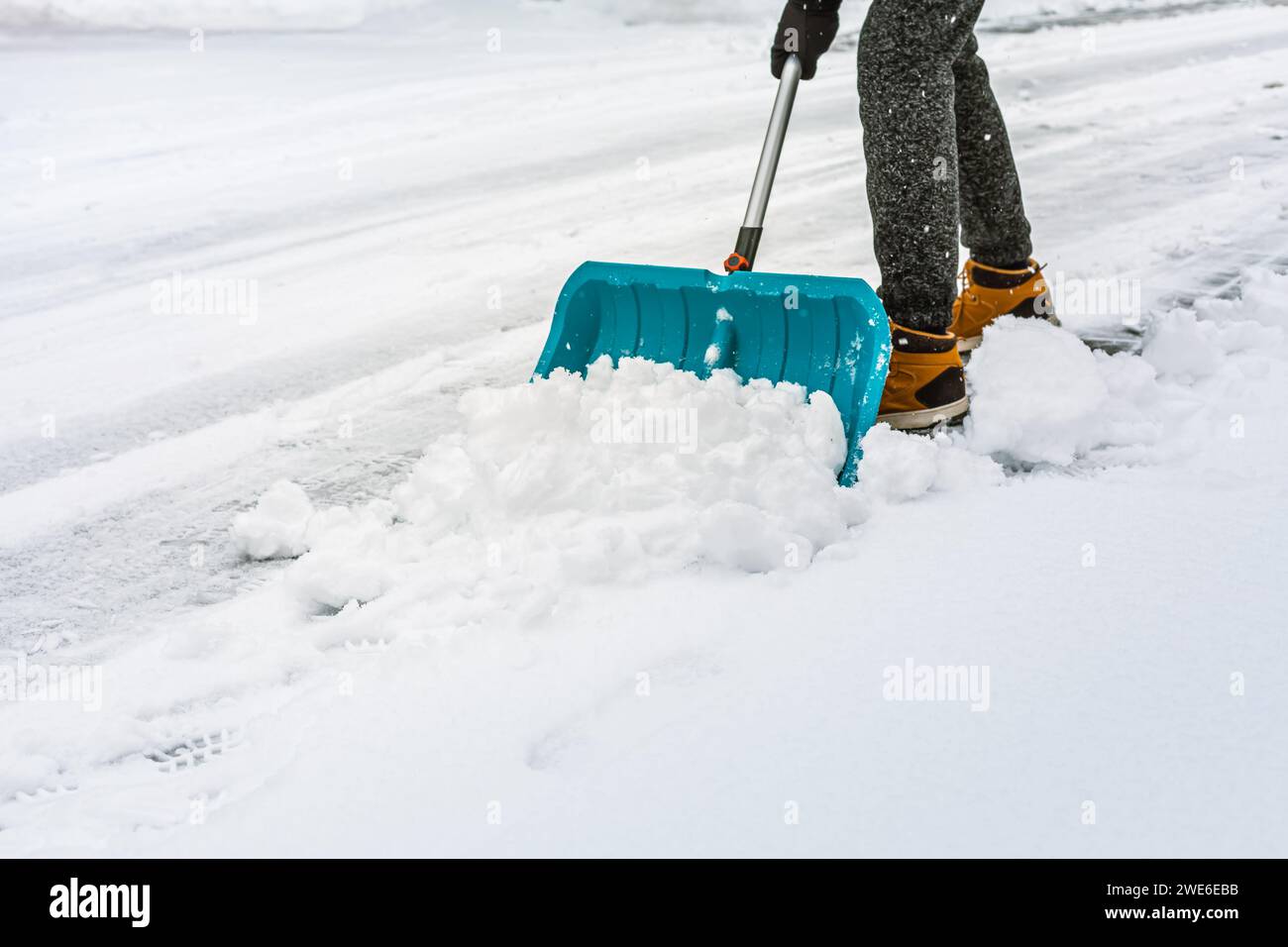 Cleaning snow from street in winter with shovel after snowstorm ...