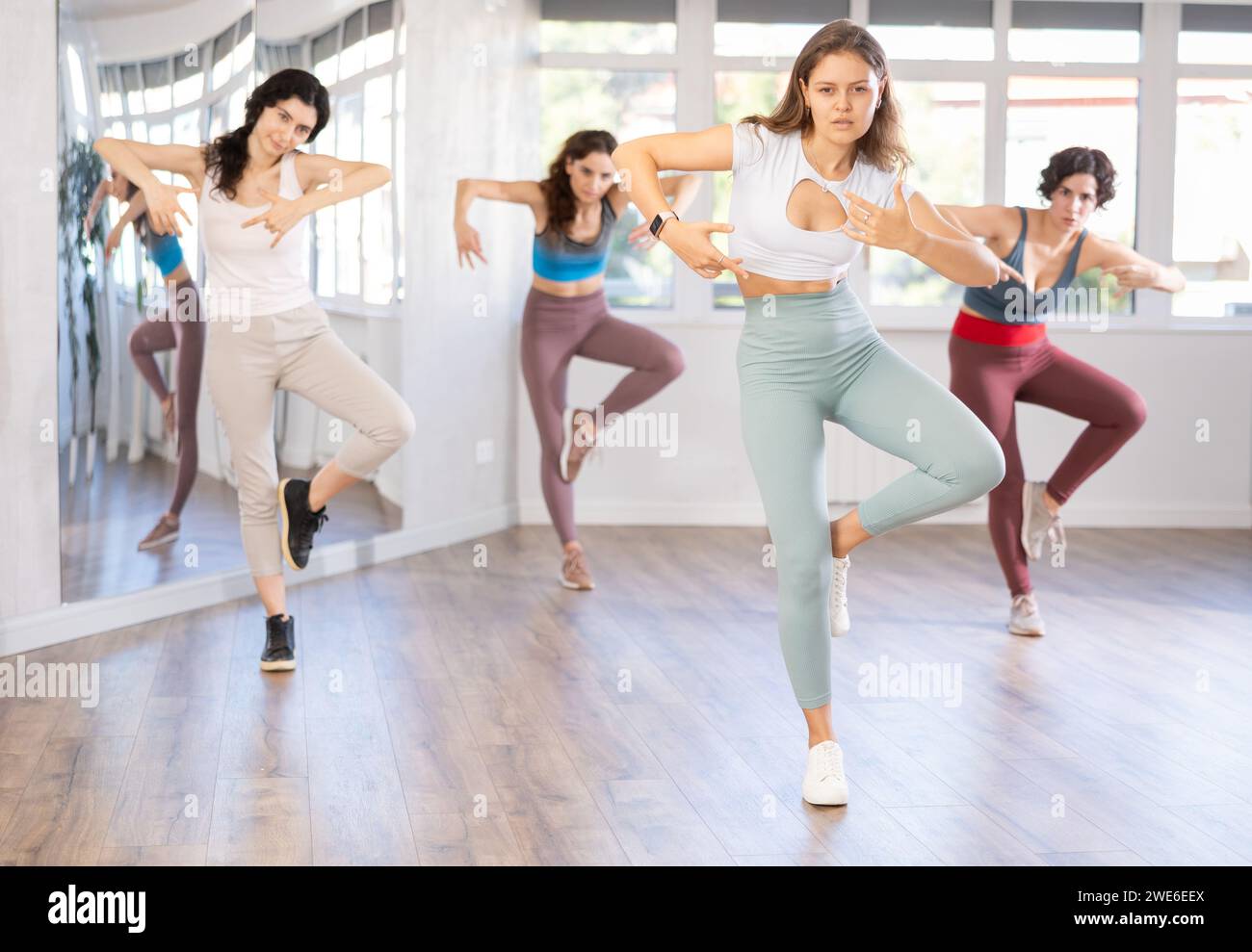 Young female teacher conducts modern hip hop dance lessons for group of ...