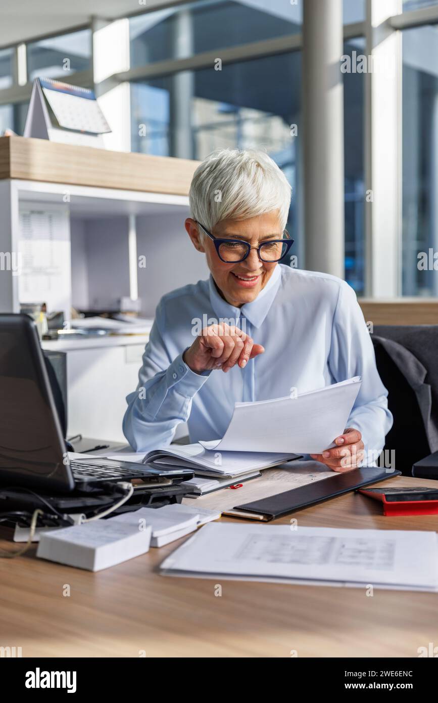 Senior business worker reading document hi-res stock photography and ...