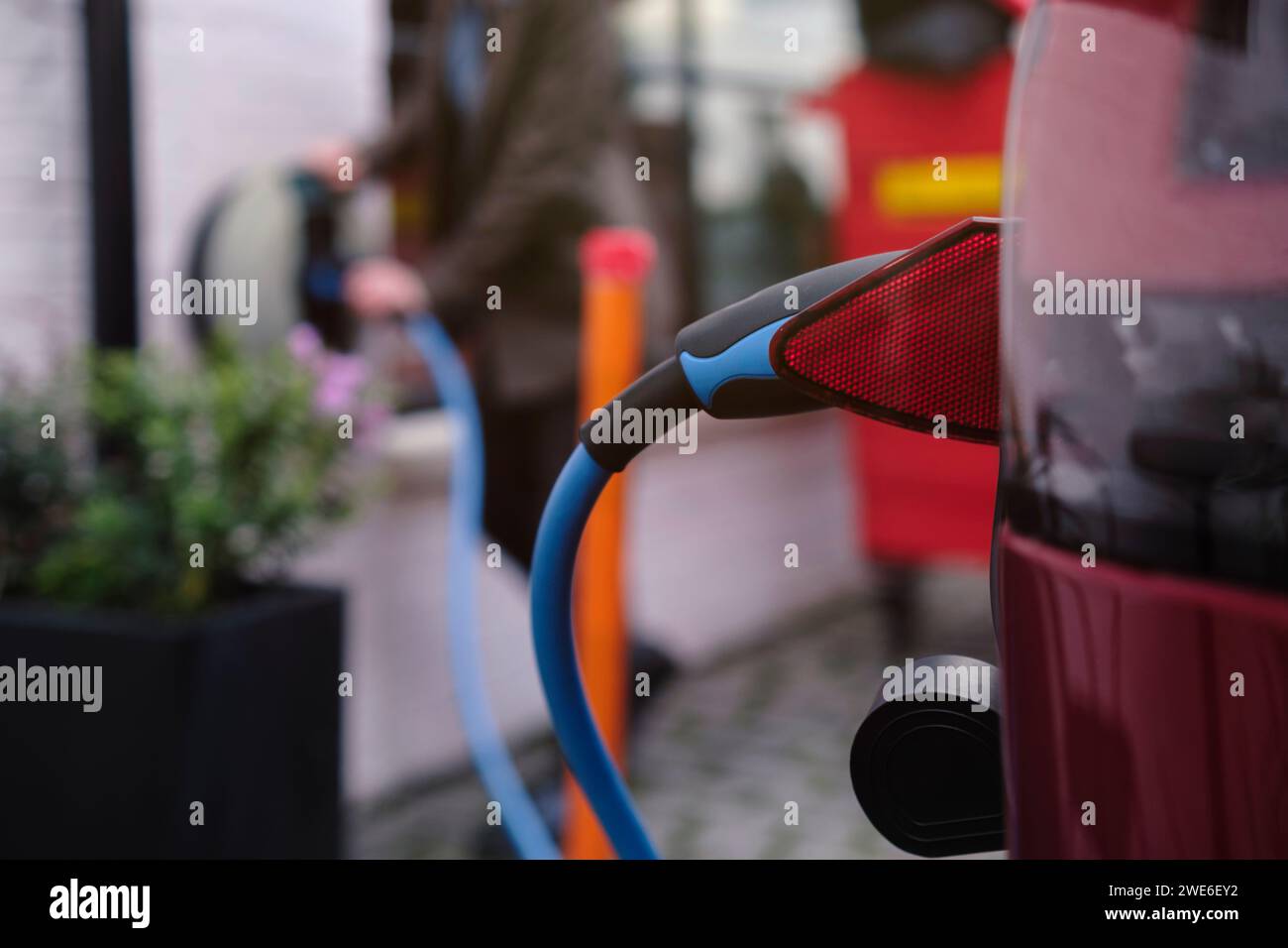 Electric plug connected to car charging at station Stock Photo - Alamy