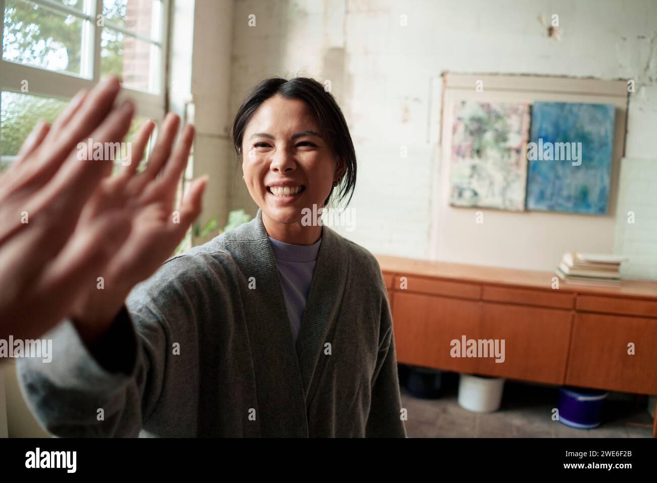Happy artist giving high-five at art studio Stock Photo - Alamy