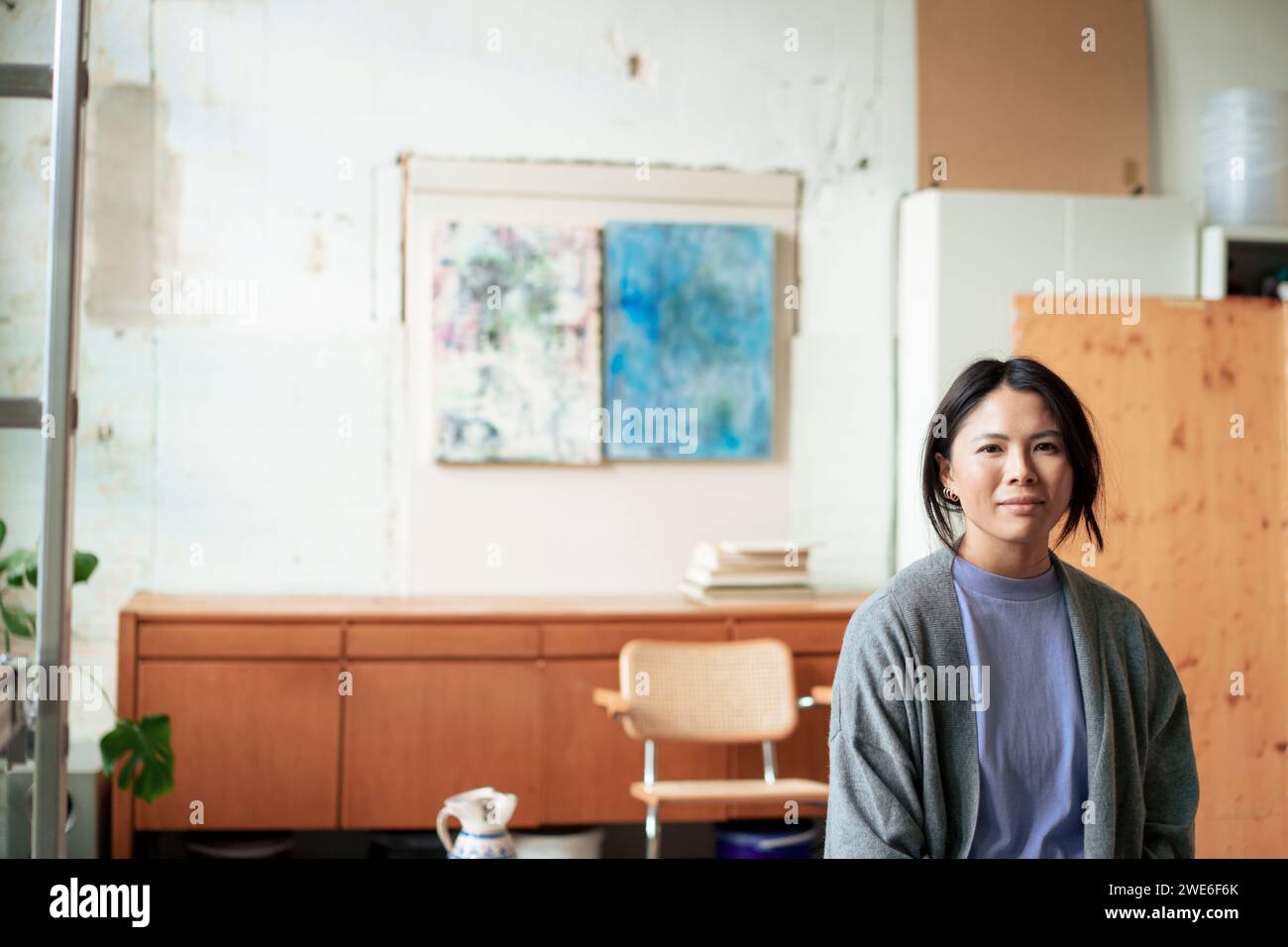 Smiling painter sitting in art workshop Stock Photo - Alamy