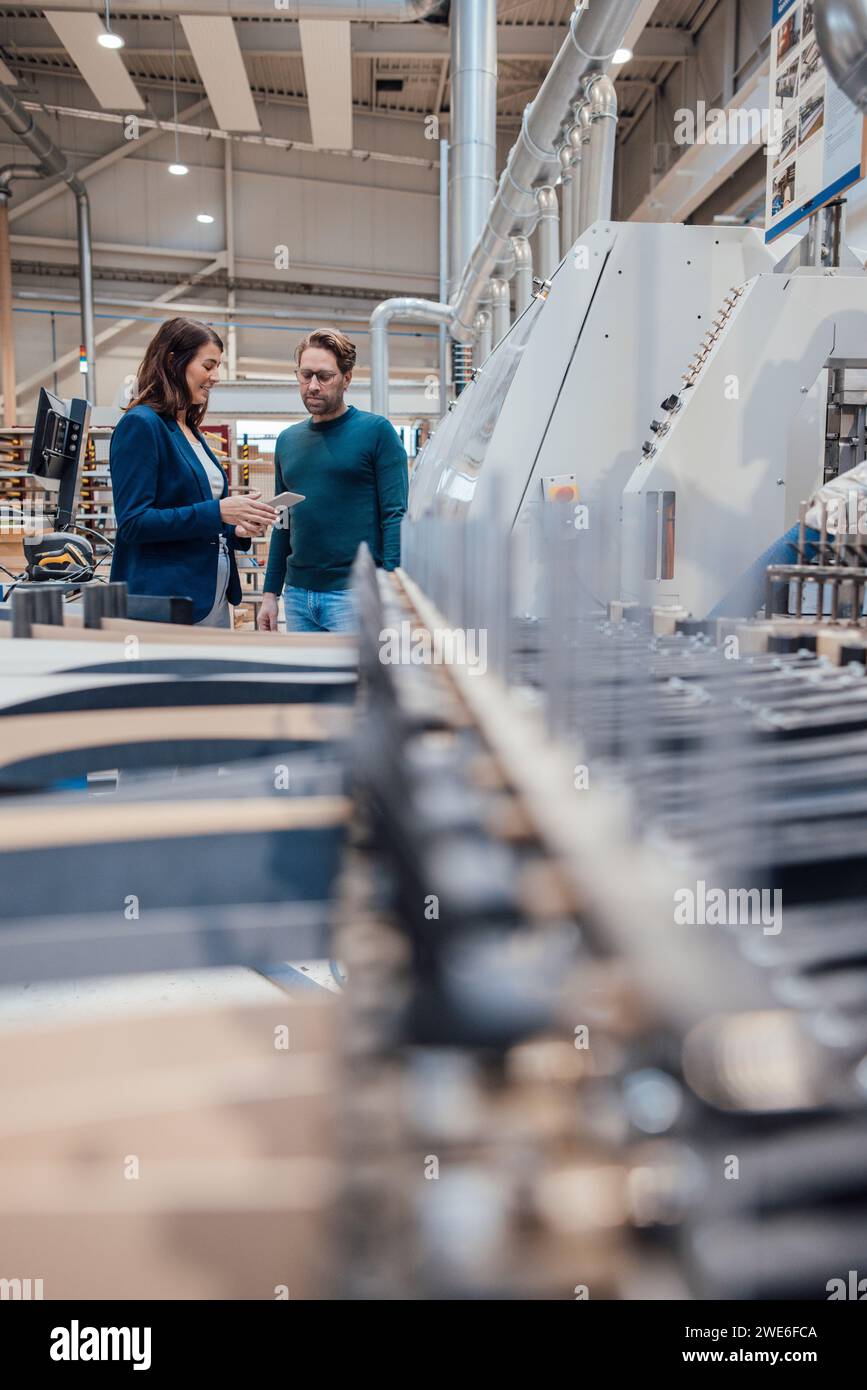 Business colleagues discussing over tablet PC in workshop Stock Photo ...