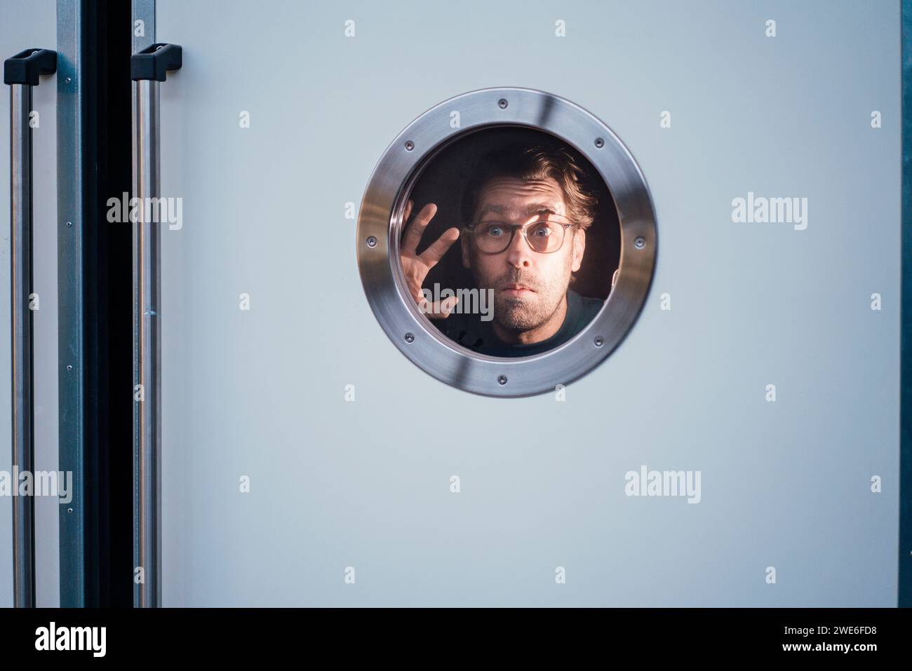 Shocked businessman looking through peephole Stock Photo - Alamy