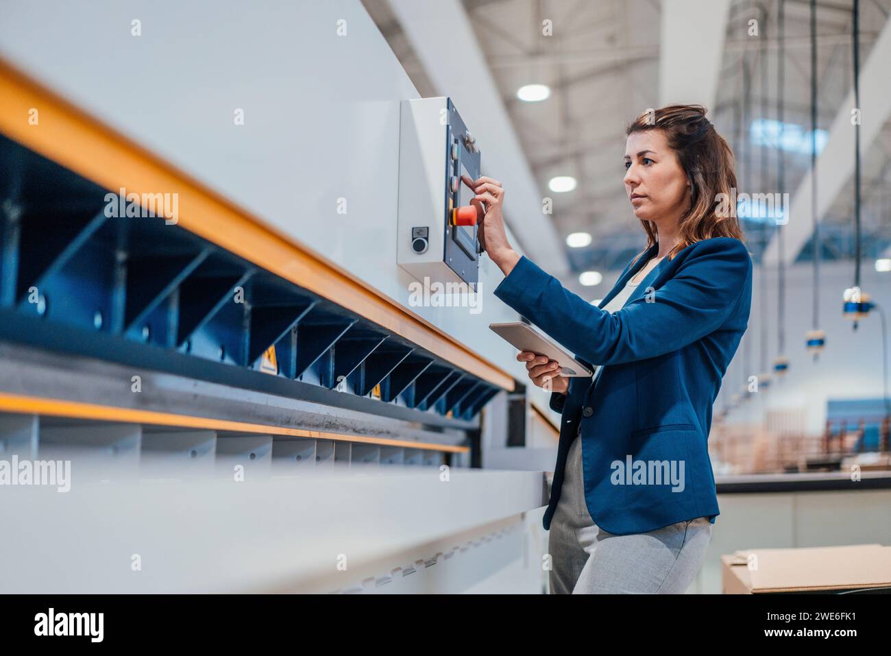 Engineer with tablet PC using control panel in industry Stock Photo - Alamy