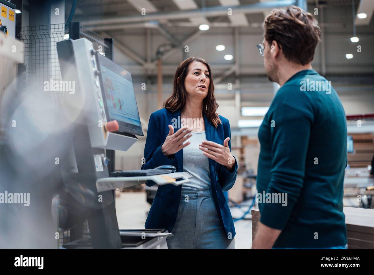 Businesswoman discussing strategy with colleague in industry Stock ...