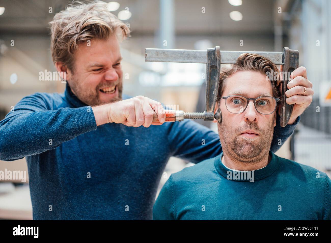 Architect with work tool on colleague in industry Stock Photo - Alamy