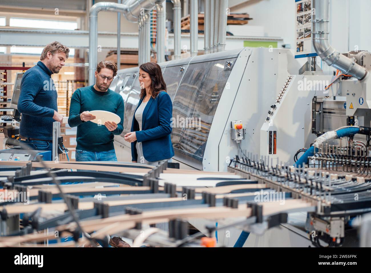 Engineers discussing over machine part in industry Stock Photo - Alamy