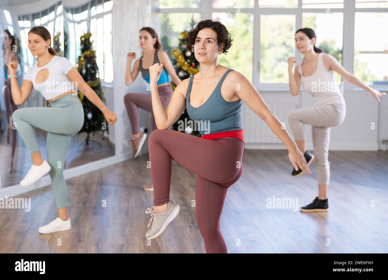 Hispanic female fitness instructor leading Zumba class in Christmas ...