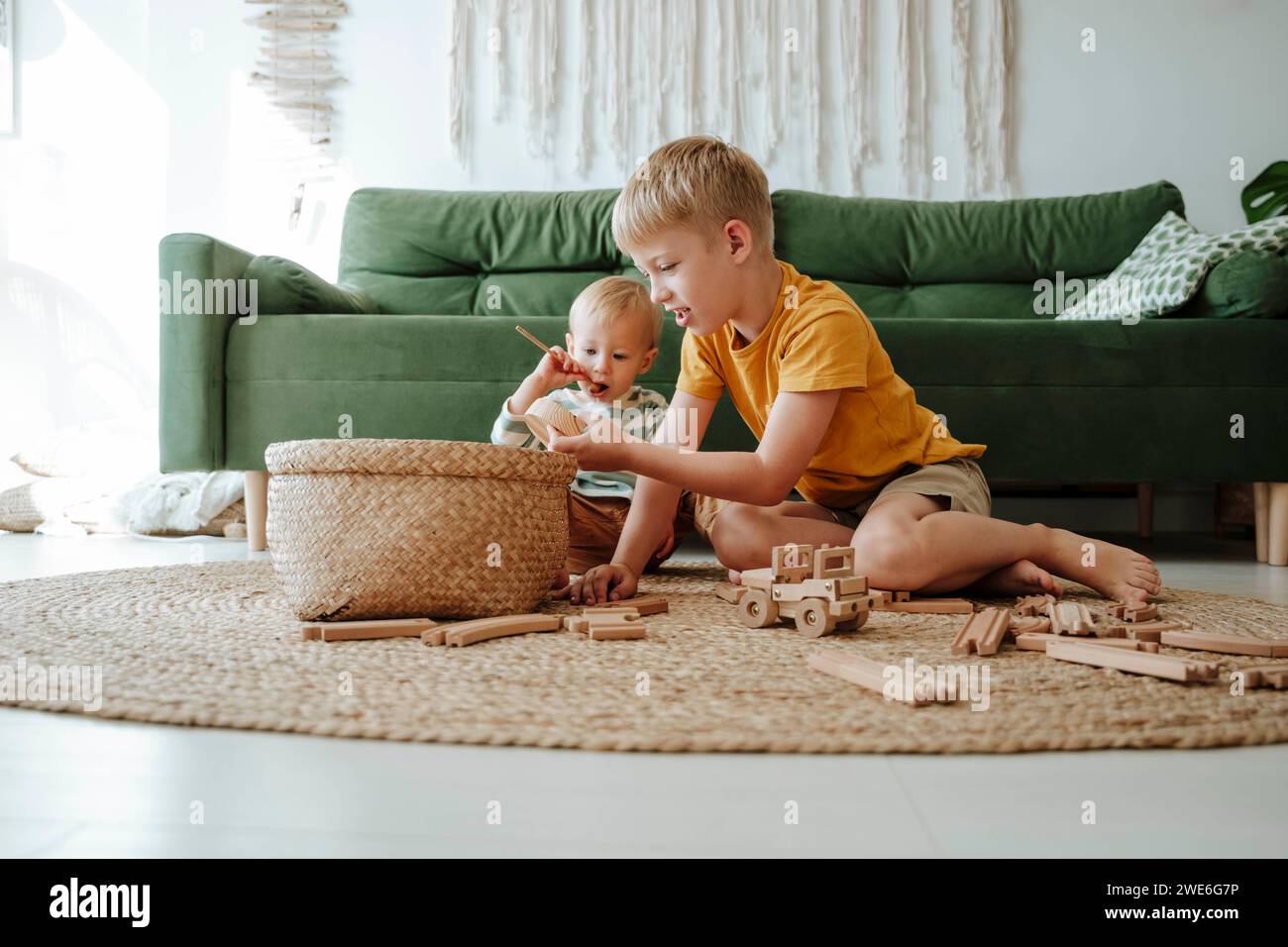 Two brothers playing with wooden train set in living room at home Stock ... Two brothers playing with wooden train set in living room at home Stock ...