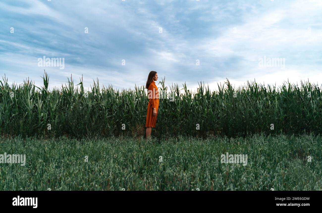 Woman standing by corn crops growing in field Stock Photo - Alamy