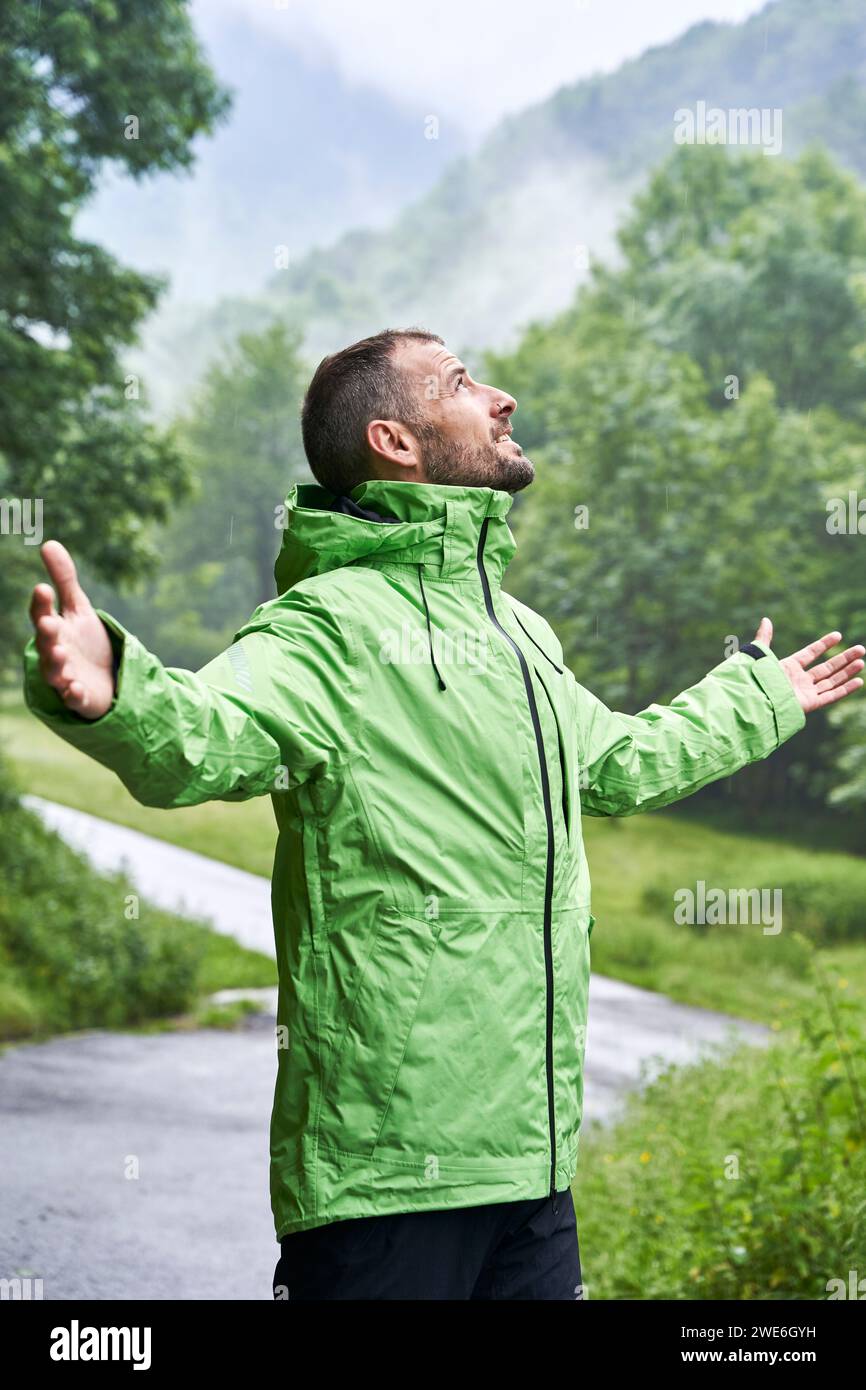 Smiling man wearing green jacket and standing in front of trees Stock ...