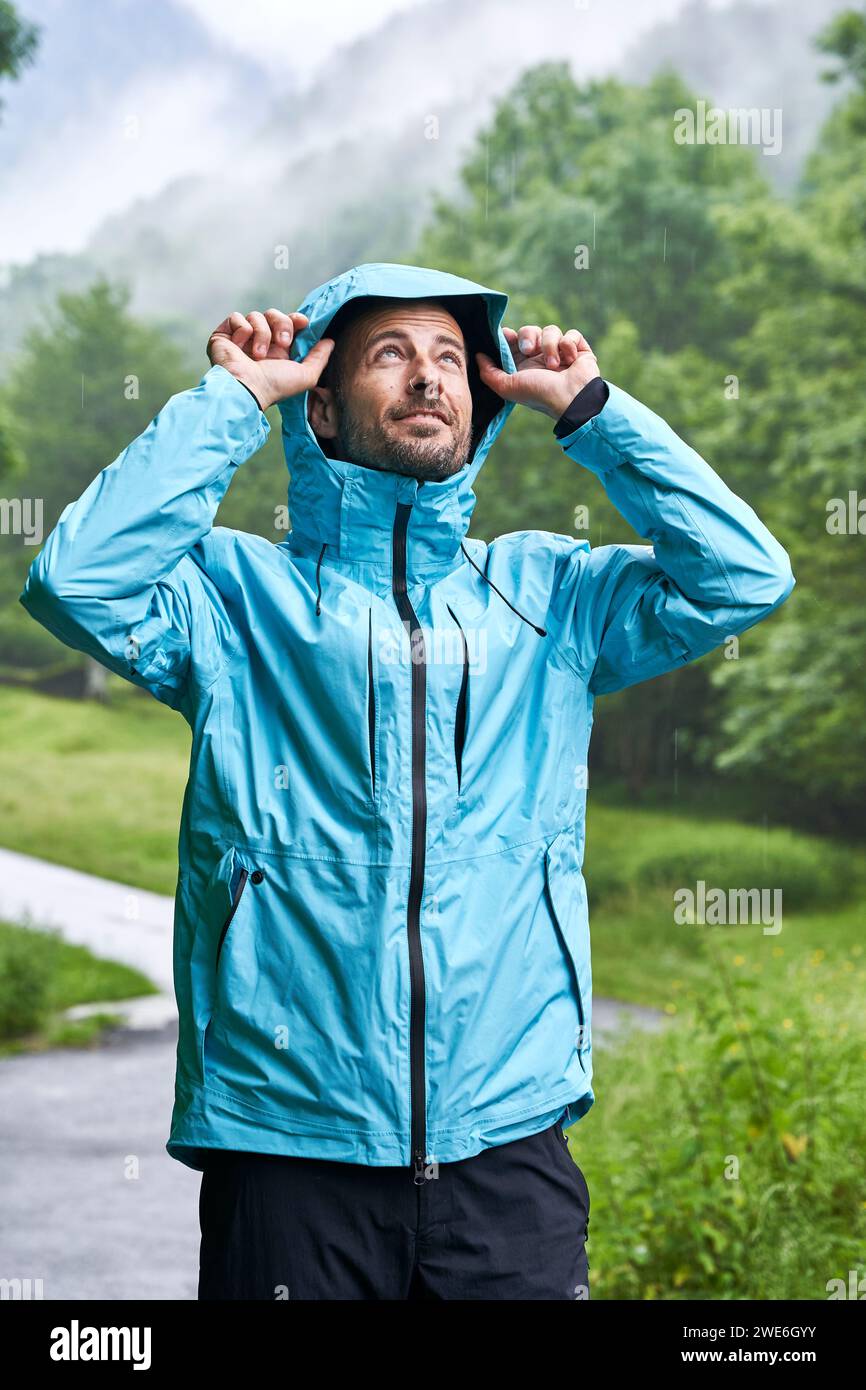 Smiling man wearing blue jacket and standing in front of trees Stock ...