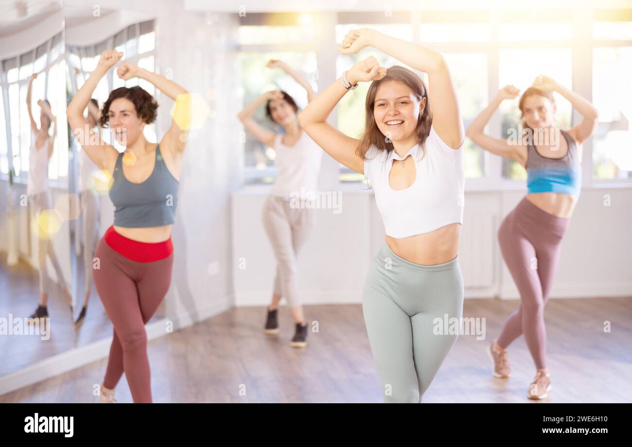 Young female teacher conducts modern hip hop dance lessons for group of ...