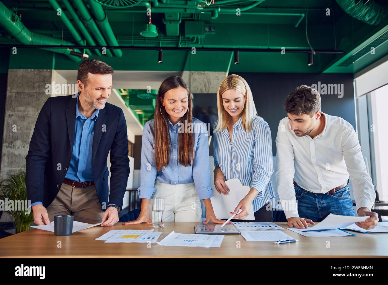 Smiling business peoples having meeting and discussing over graphs ...
