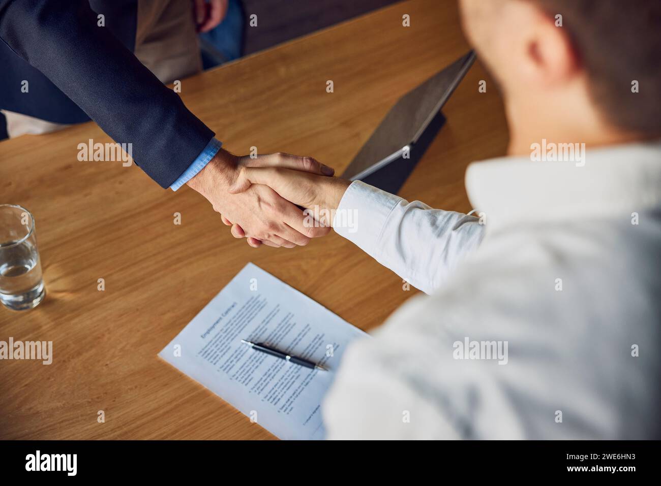 Recruiter shaking hands with candidate at desk Stock Photo - Alamy