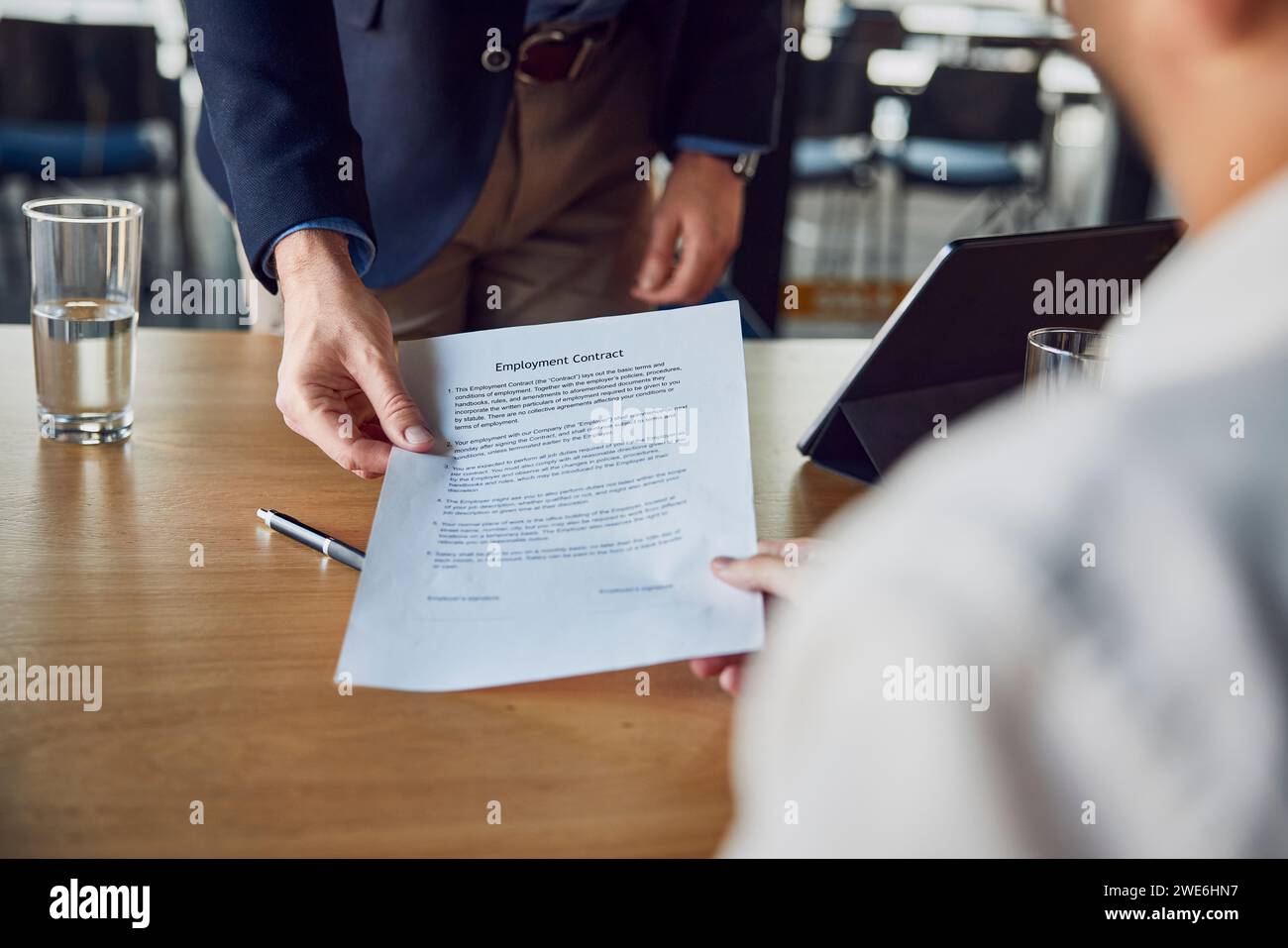 Recruiter giving contract to candidate at desk Stock Photo - Alamy
