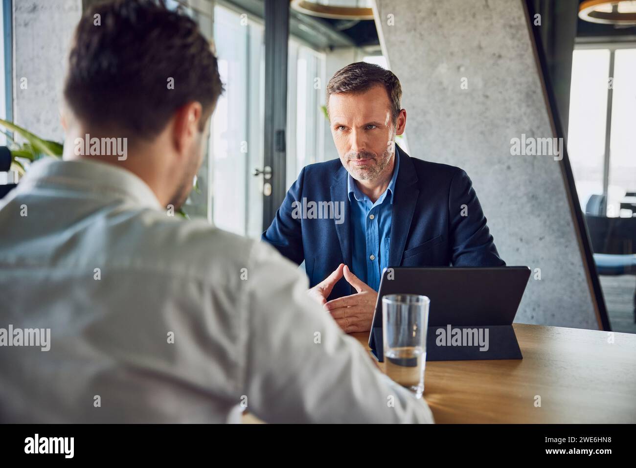 Serious recruiter taking interview of candidate at desk Stock Photo - Alamy