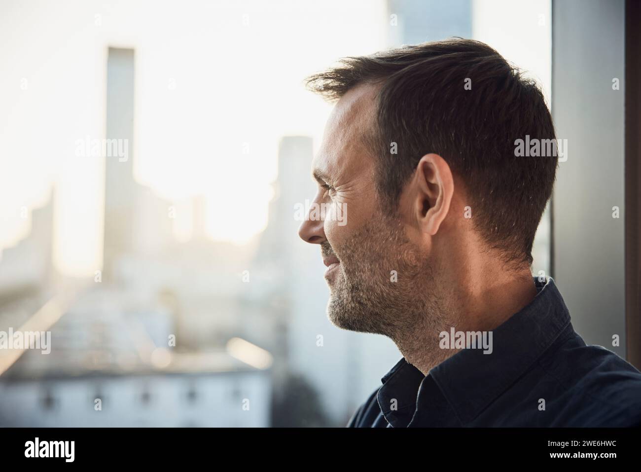 Thoughtful businessman looking through office window Stock Photo - Alamy