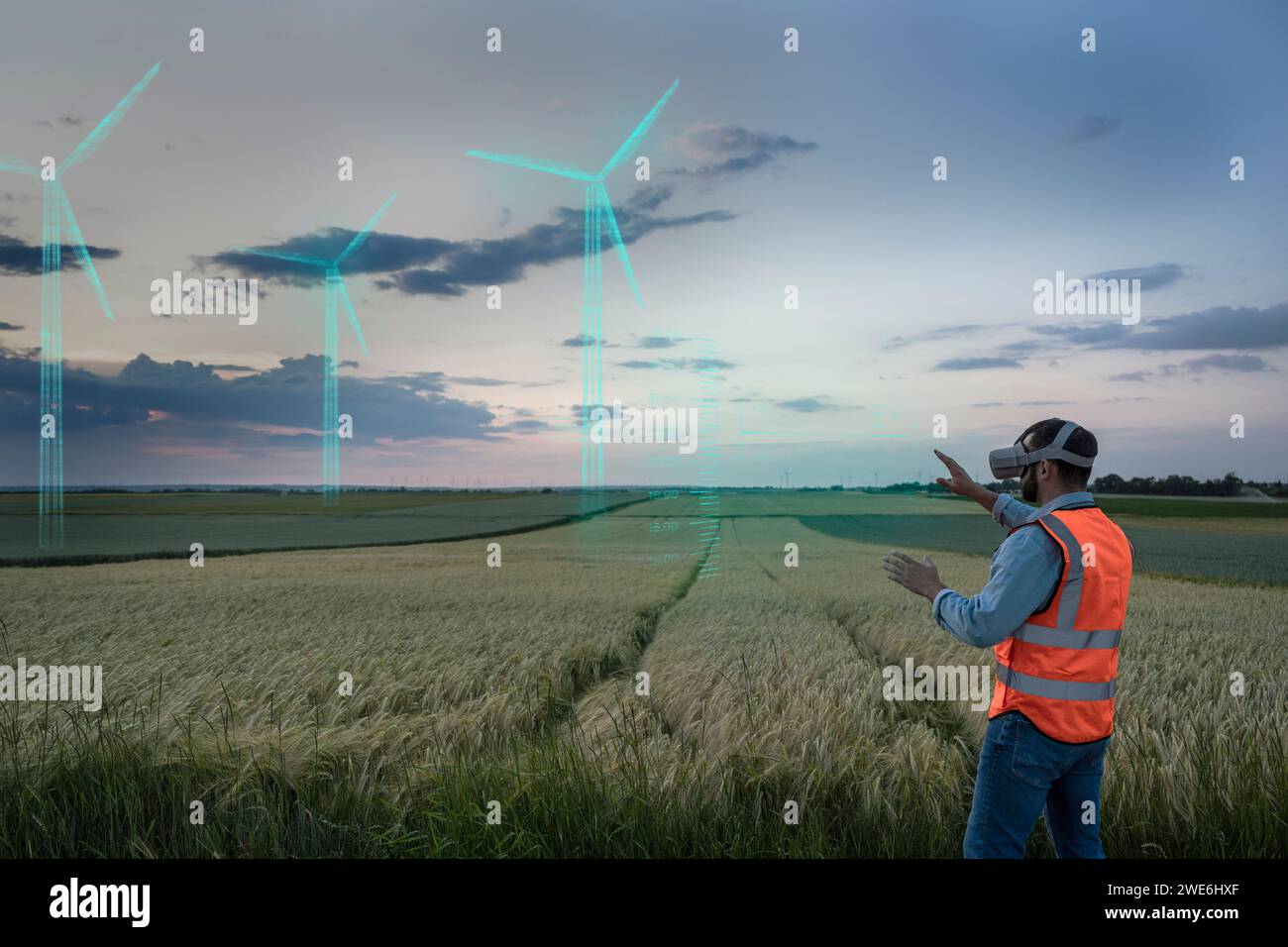 Engineer looking at digital wind turbine models in field Stock Photo ...