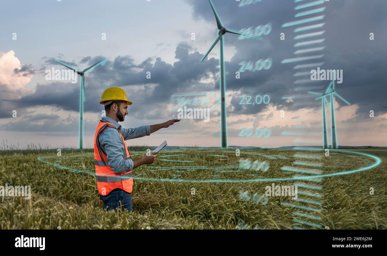 Engineer wearing hardhat and programming digital wind turbine through ...
