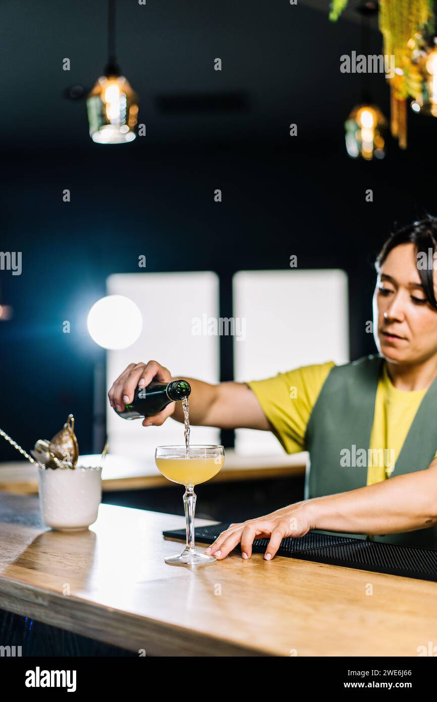 Bartender pouring drink in cocktail glass on bar counter Stock Photo - Alamy