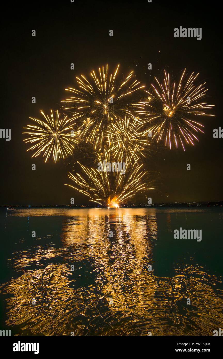 Italy, Veneto, Fireworks exploding over lake Garda at night Stock Photo ...